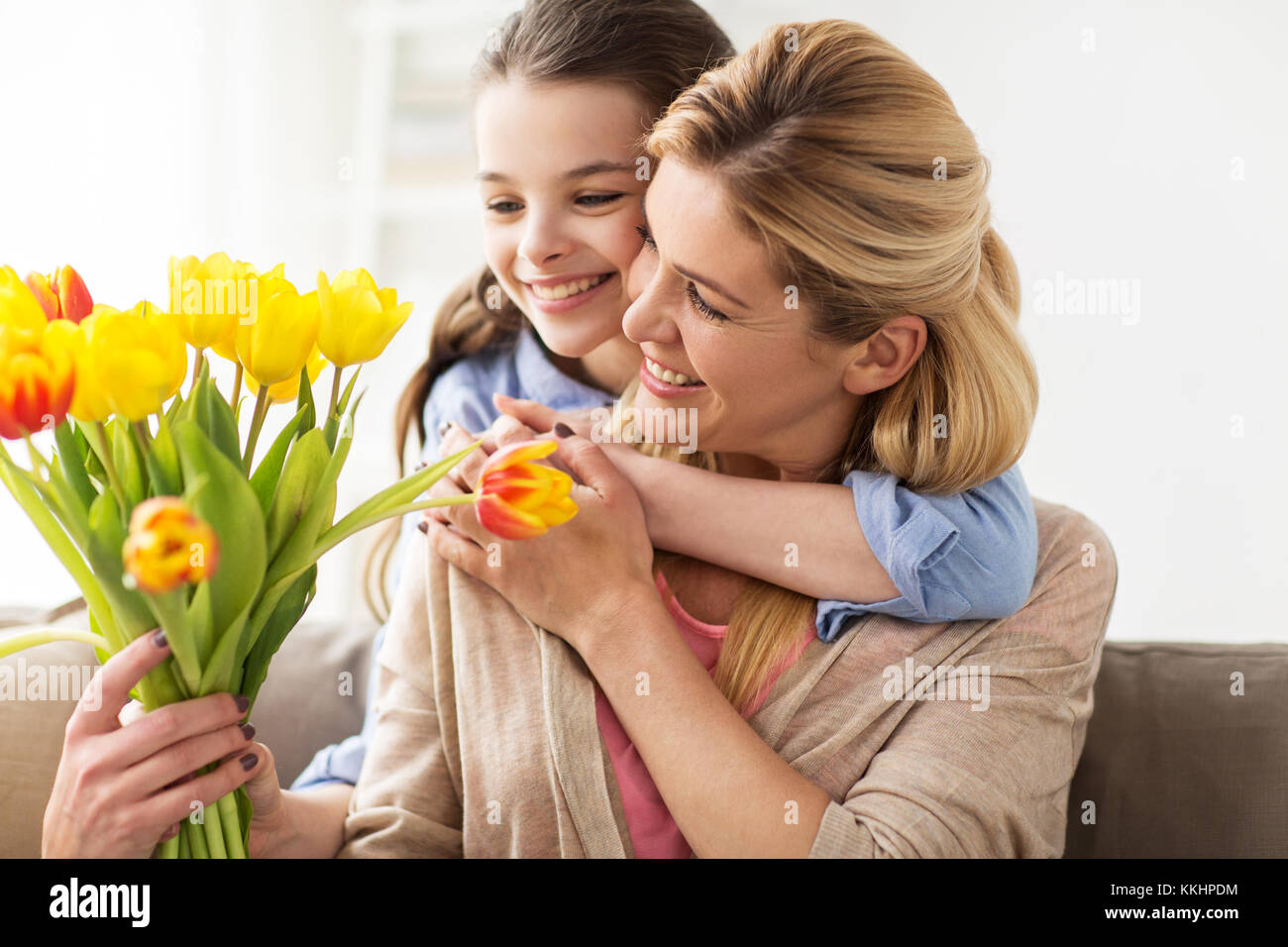 happy girl giving flowers to mother at home Stock Photo - Alamy
