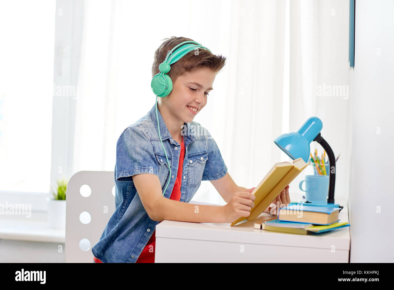 student boy in headphones reading book at home Stock Photo - Alamy