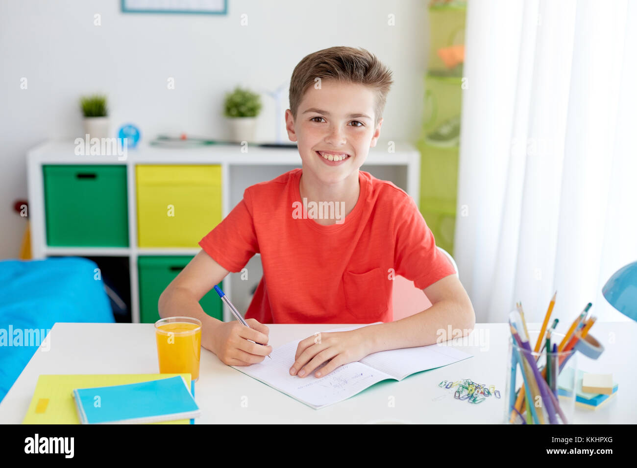 happy student boy writing to notebook at home Stock Photo - Alamy