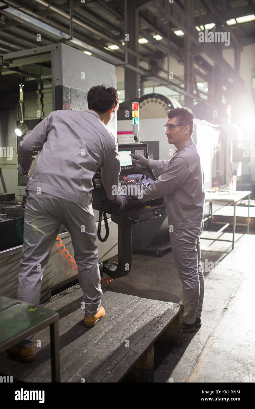Confident Chinese engineers working in the factory Stock Photo - Alamy