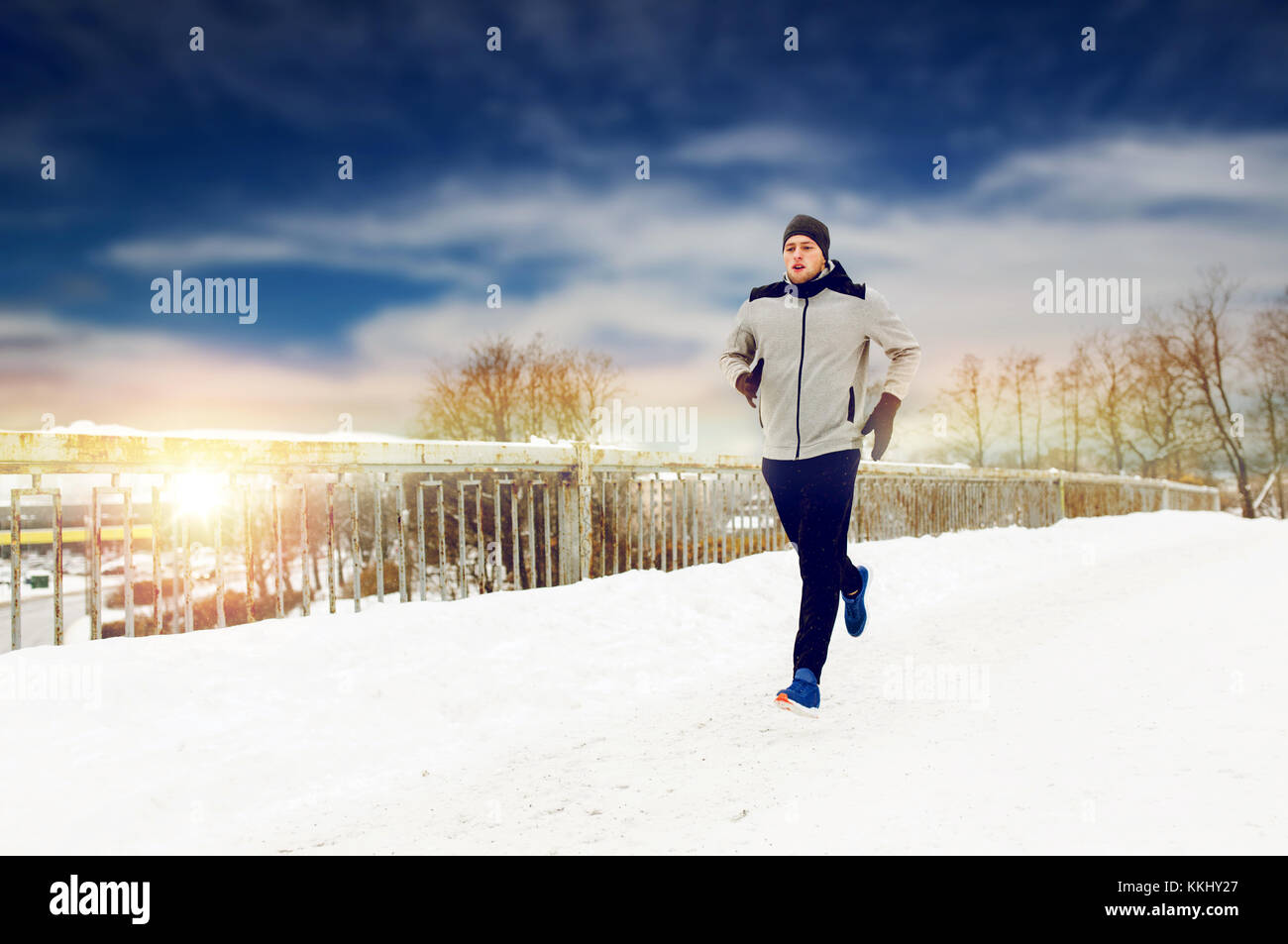 man running along snow covered winter bridge road Stock Photo - Alamy