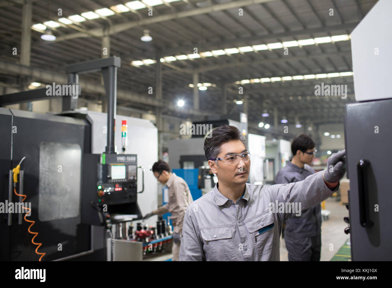 Confident Chinese engineers working in the factory Stock Photo - Alamy