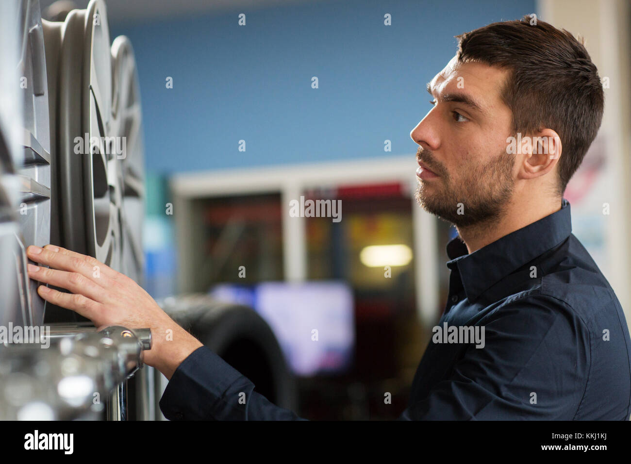 male customer choosing wheel rims at car service Stock Photo - Alamy