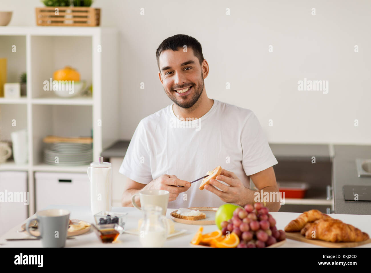 man eating toast with coffee at home kitchen Stock Photo - Alamy