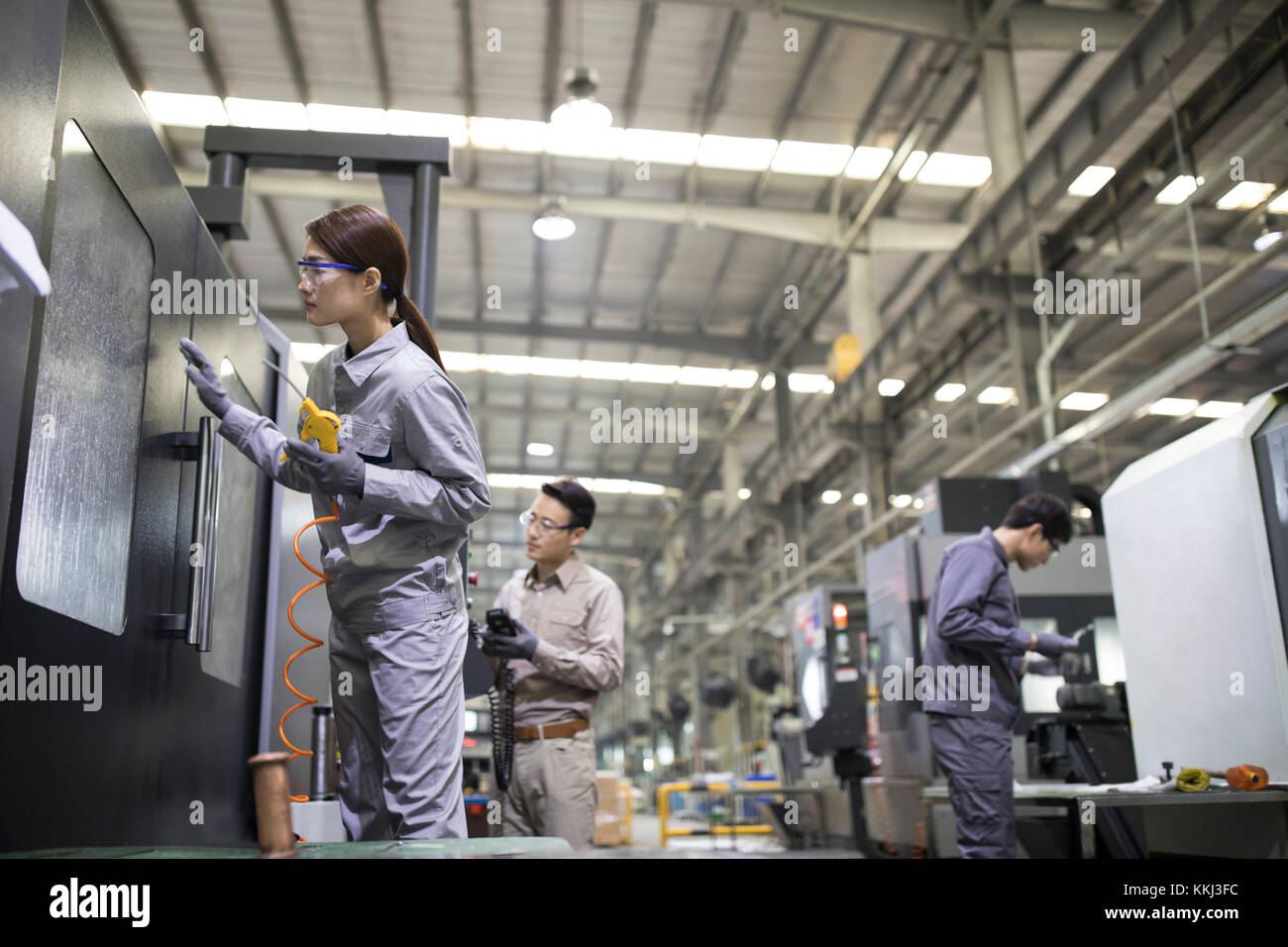Confident Chinese engineers working in the factory Stock Photo - Alamy