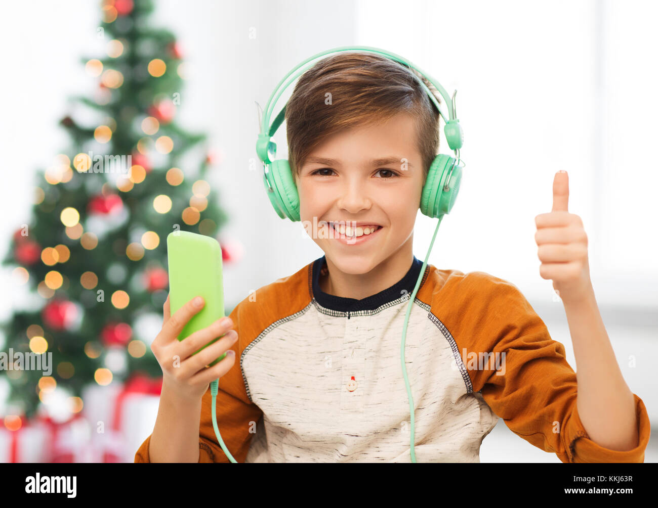 boy with smartphone and headphones at christmas Stock Photo - Alamy