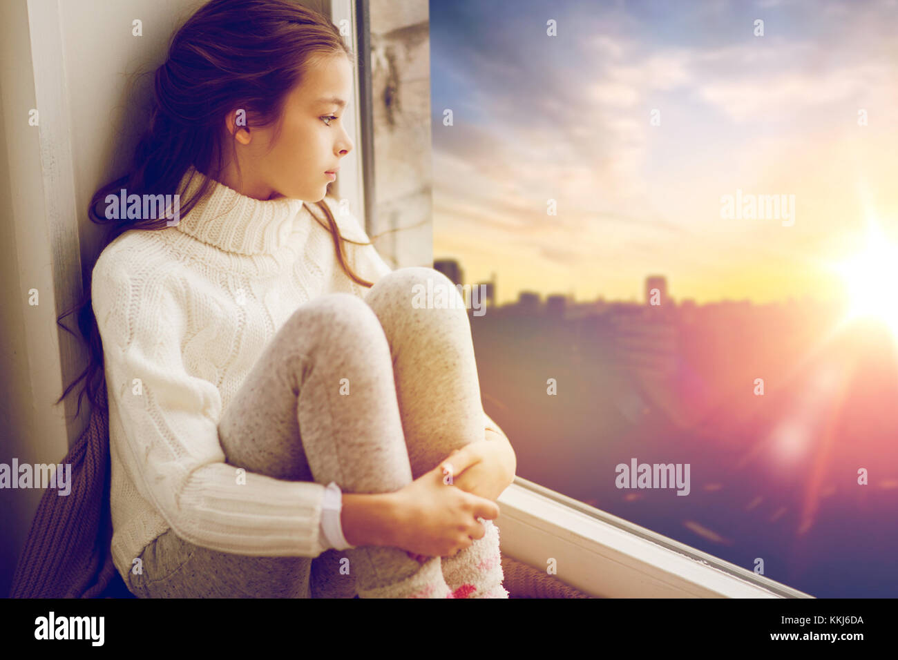 sad girl sitting on sill at home window Stock Photo - Alamy