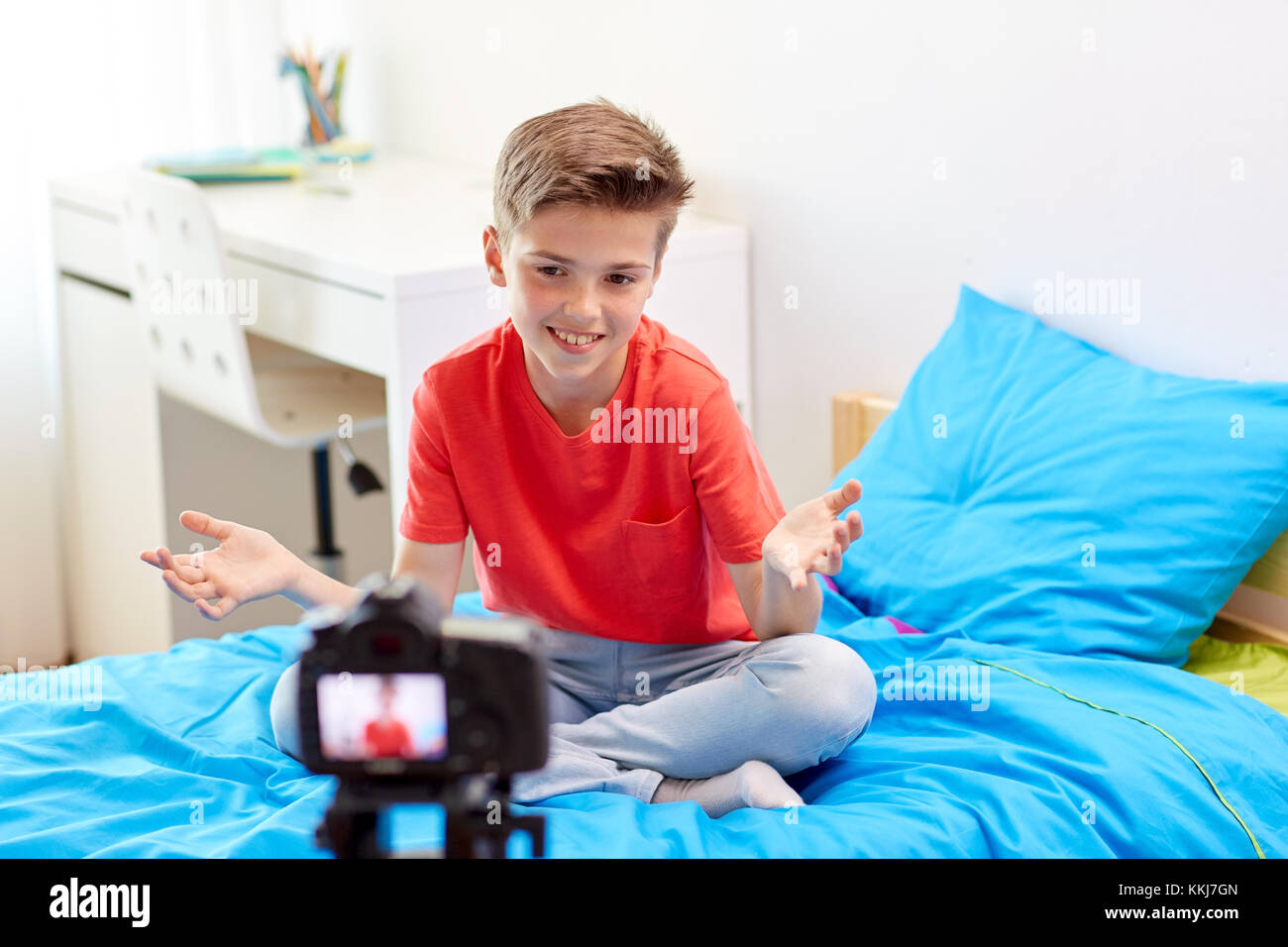 happy boy with camera recording video at home Stock Photo - Alamy