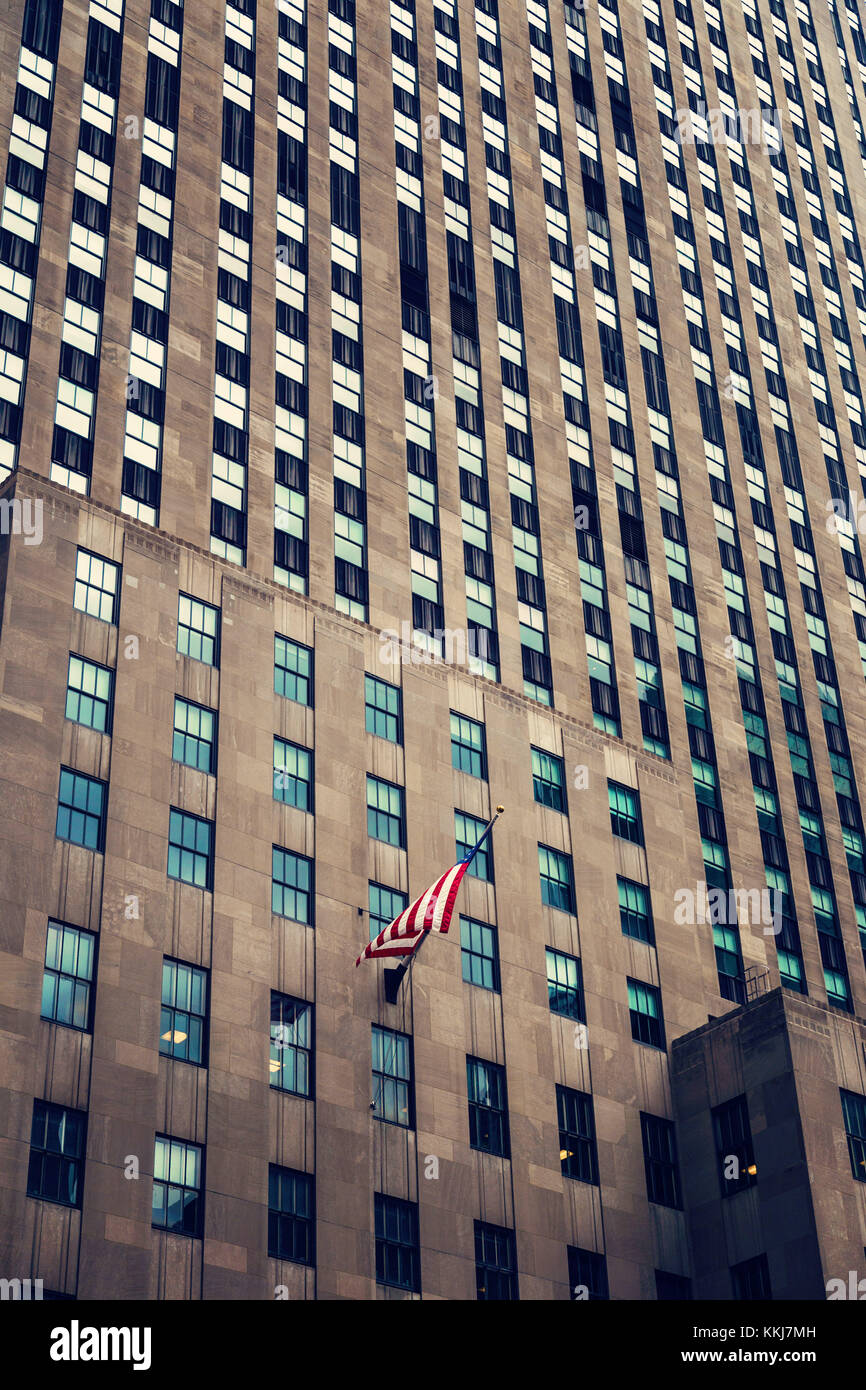 Vintage toned American flag in front of building glass wall, Midtown ...