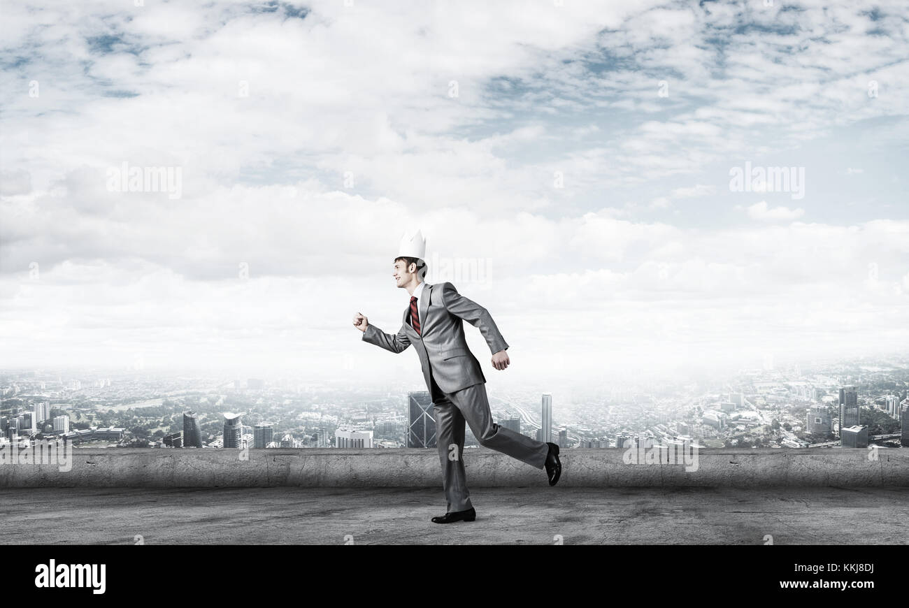 King businessman in elegant suit running on building roof and bu Stock ...