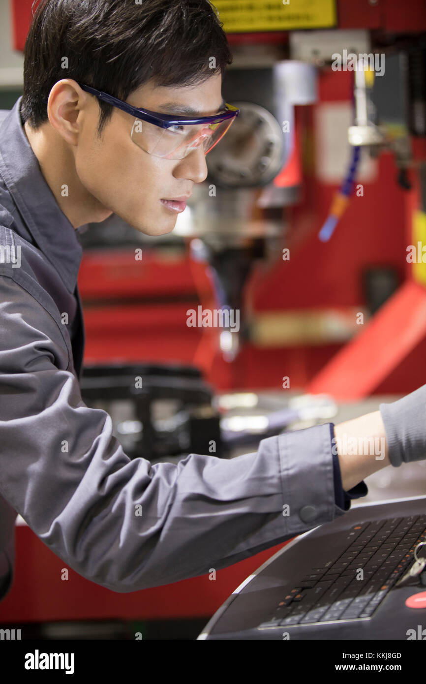 Confident Chinese engineer working in the factory Stock Photo - Alamy