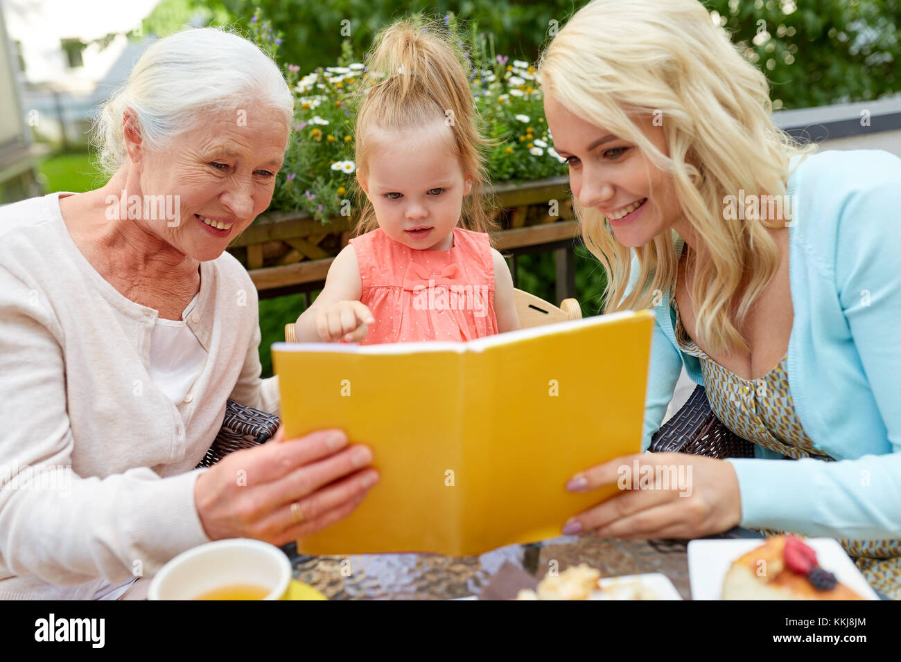 happy family reading book at cafe terrace Stock Photo - Alamy