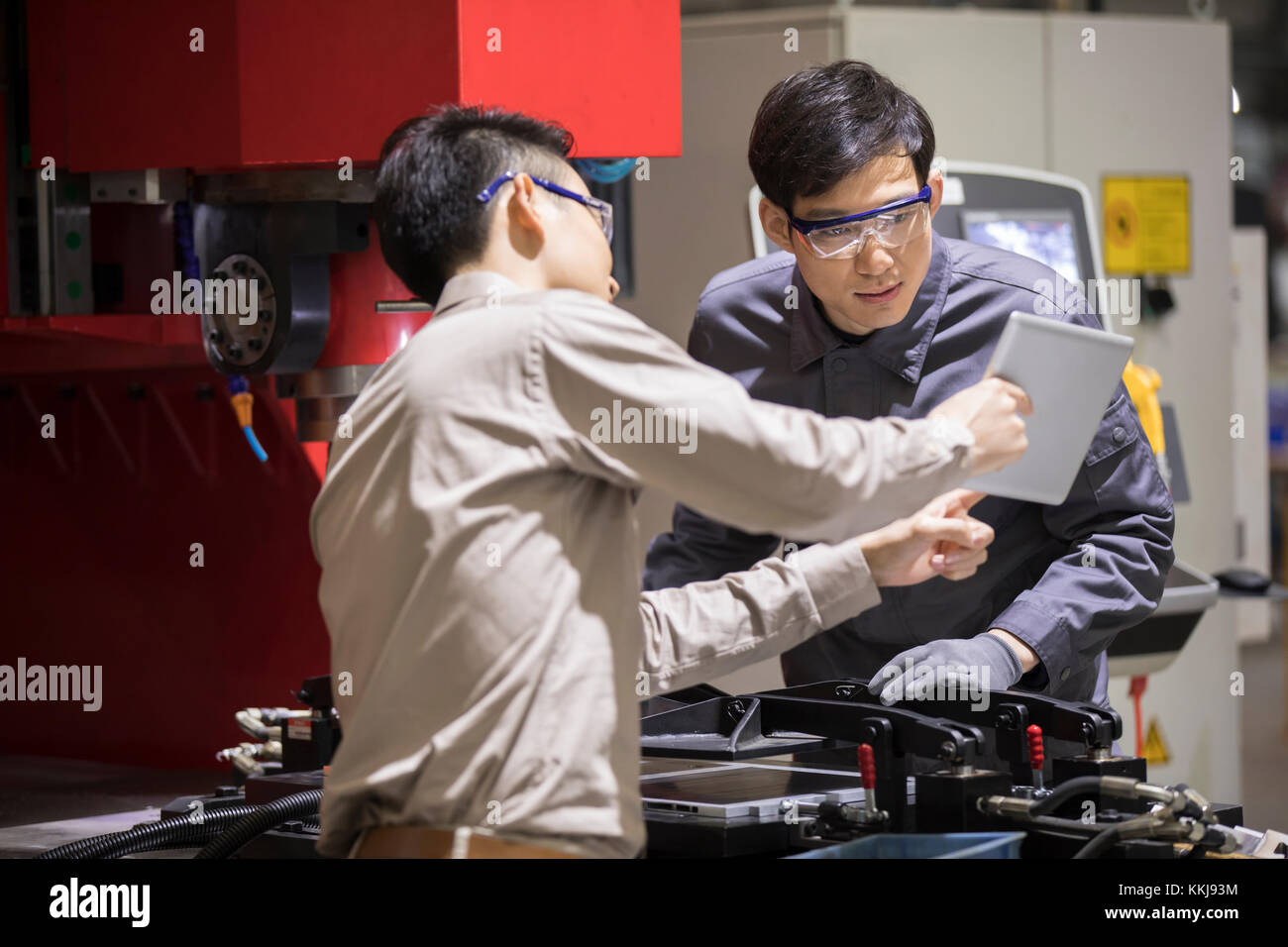 Confident Chinese engineers talking in the factory Stock Photo - Alamy