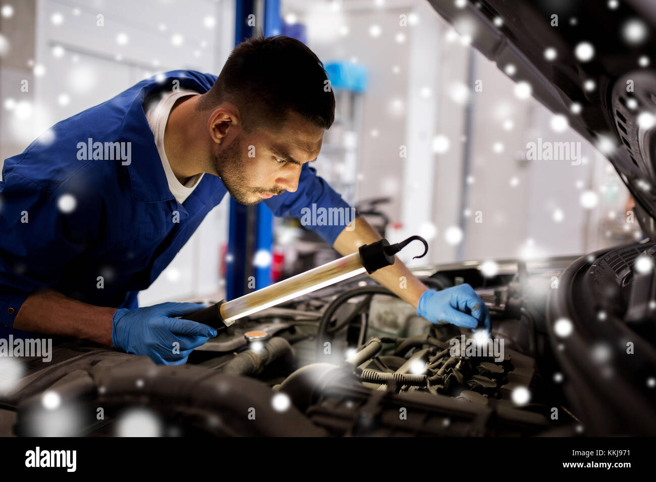 mechanic man with lamp repairing car at workshop Stock Photo - Alamy