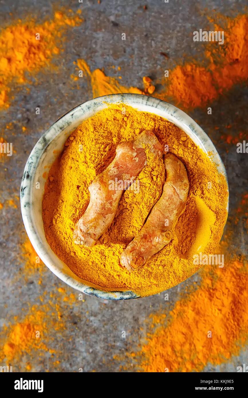 Turmeric powder and fresh turmeric. Dark background. Space for text ...