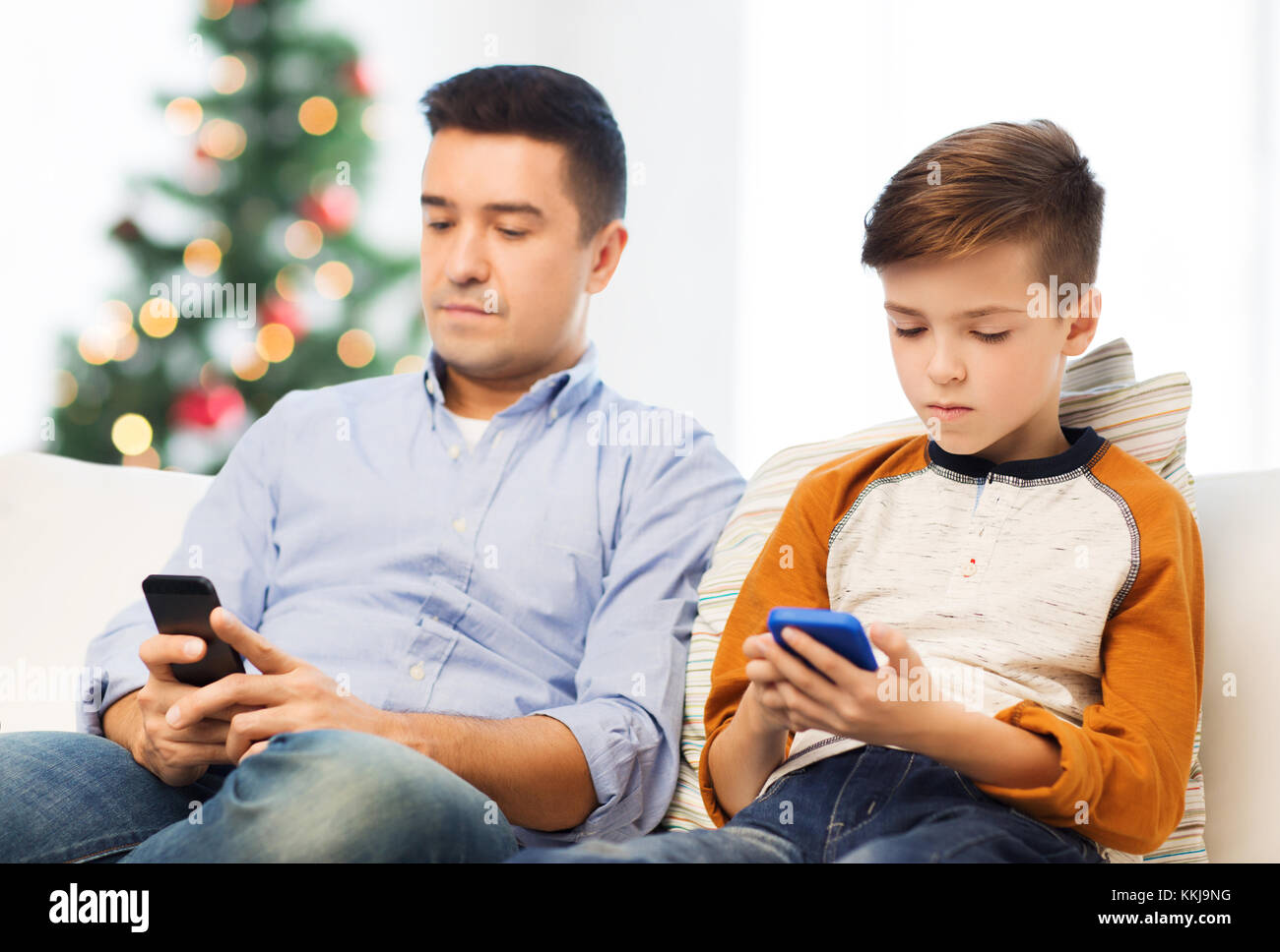 father and son with smartphones at christmas Stock Photo - Alamy