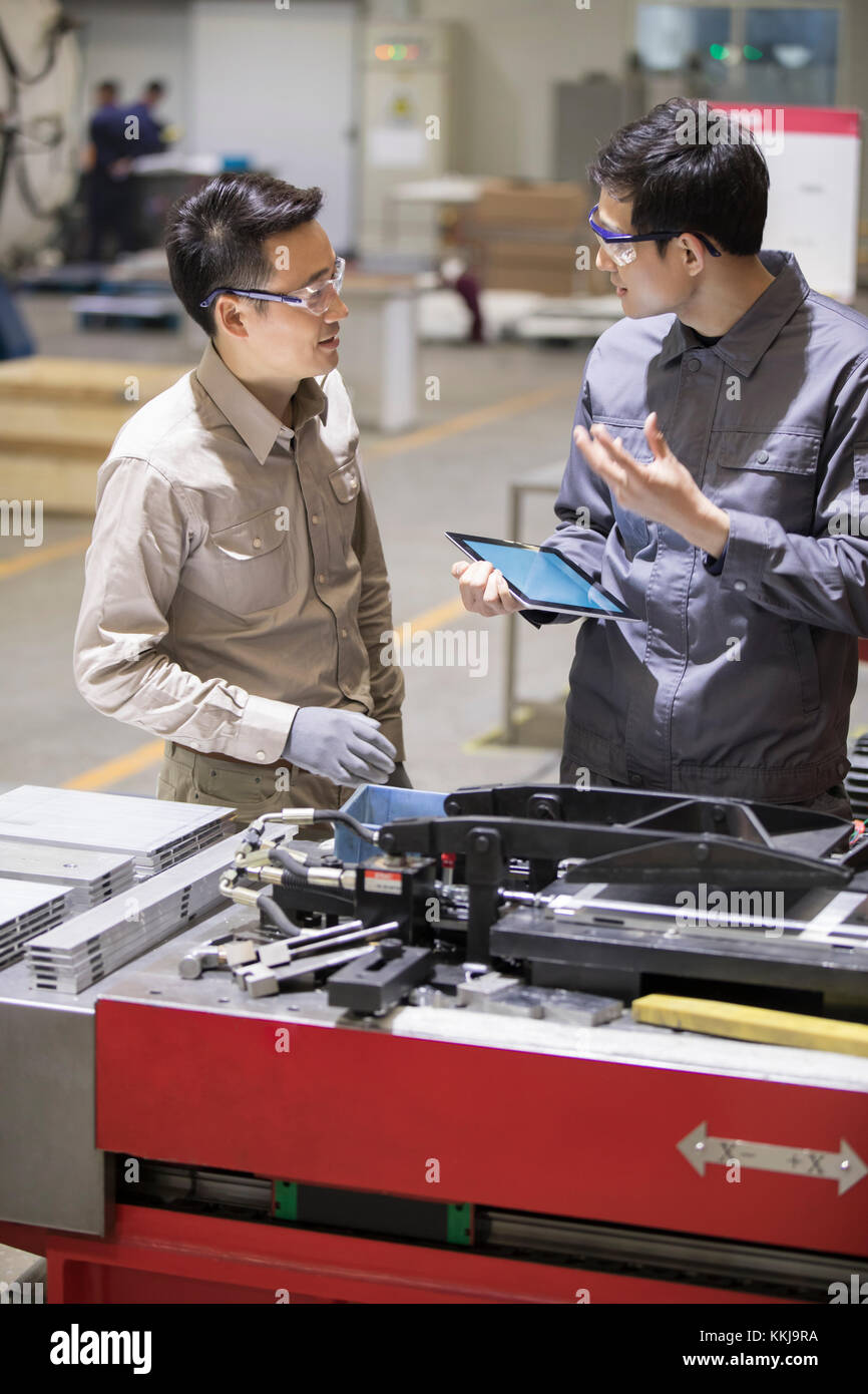 Confident Chinese engineers talking in the factory Stock Photo - Alamy