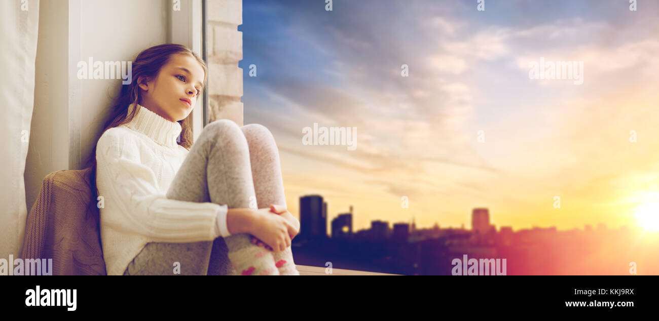 sad girl sitting on sill at home window Stock Photo - Alamy