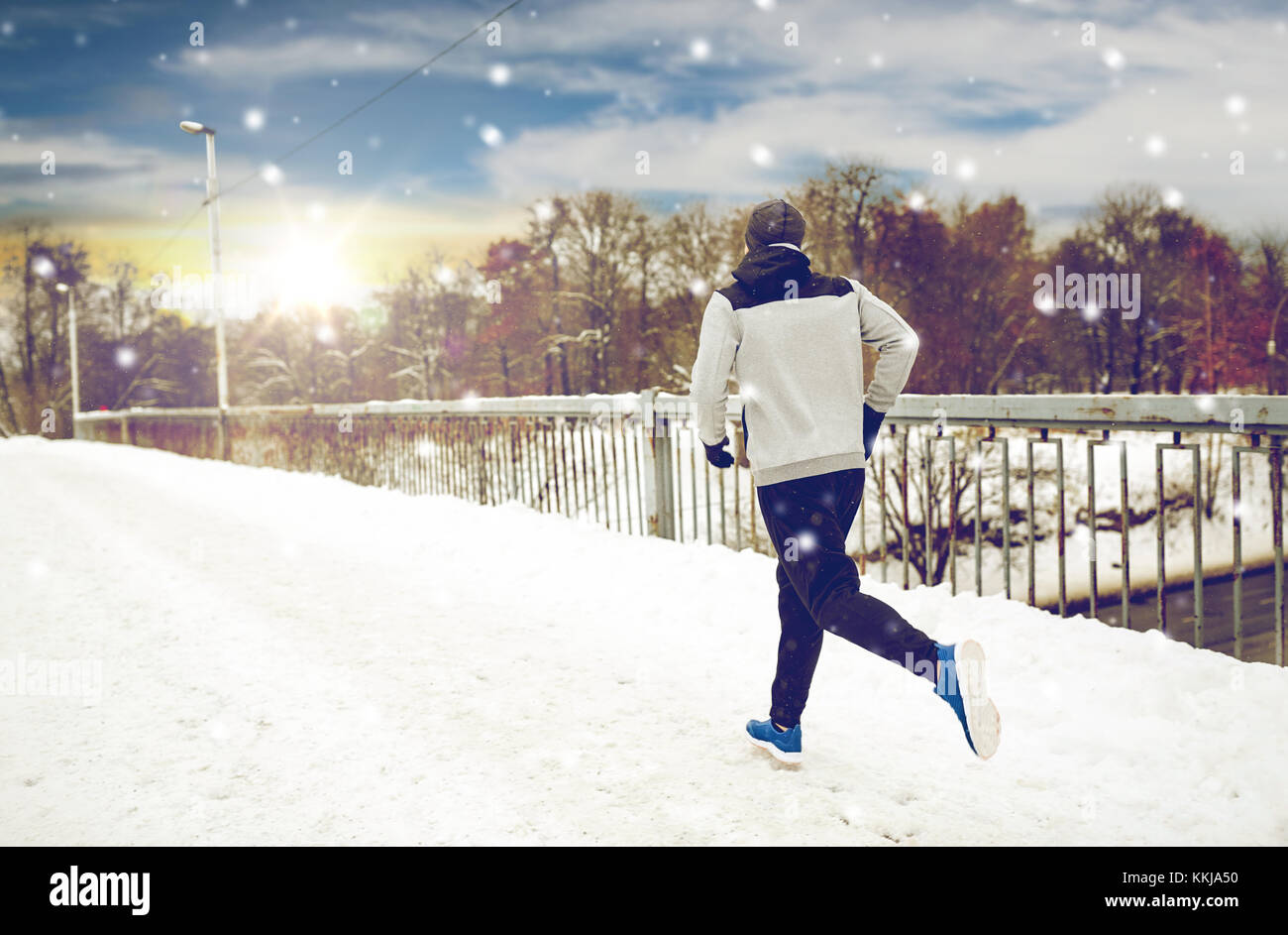 man running along snow covered winter bridge road Stock Photo - Alamy