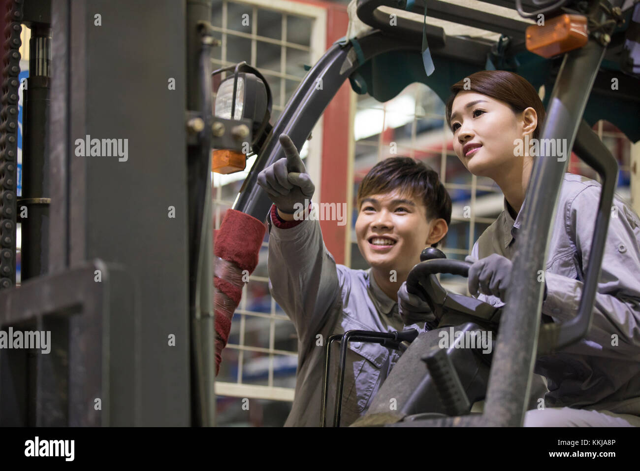 Confident Chinese workers driving forklift in the factory Stock Photo ...