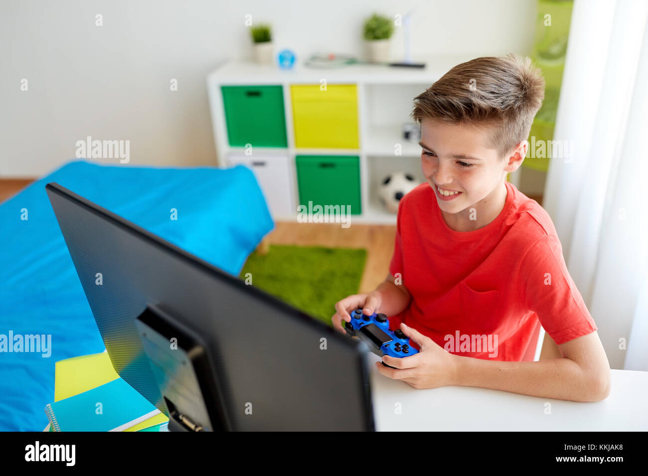 boy with gamepad playing video game on computer Stock Photo - Alamy