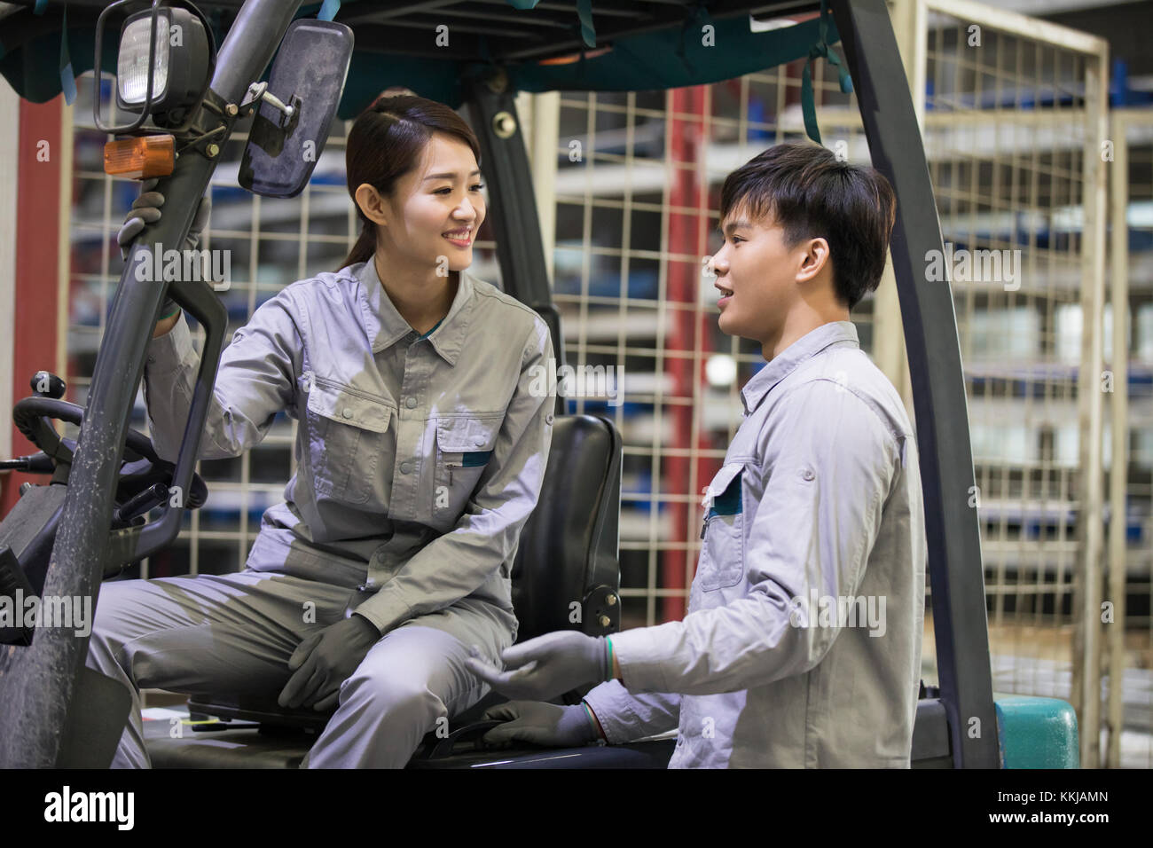 Confident Chinese workers driving forklift in the factory Stock Photo ...
