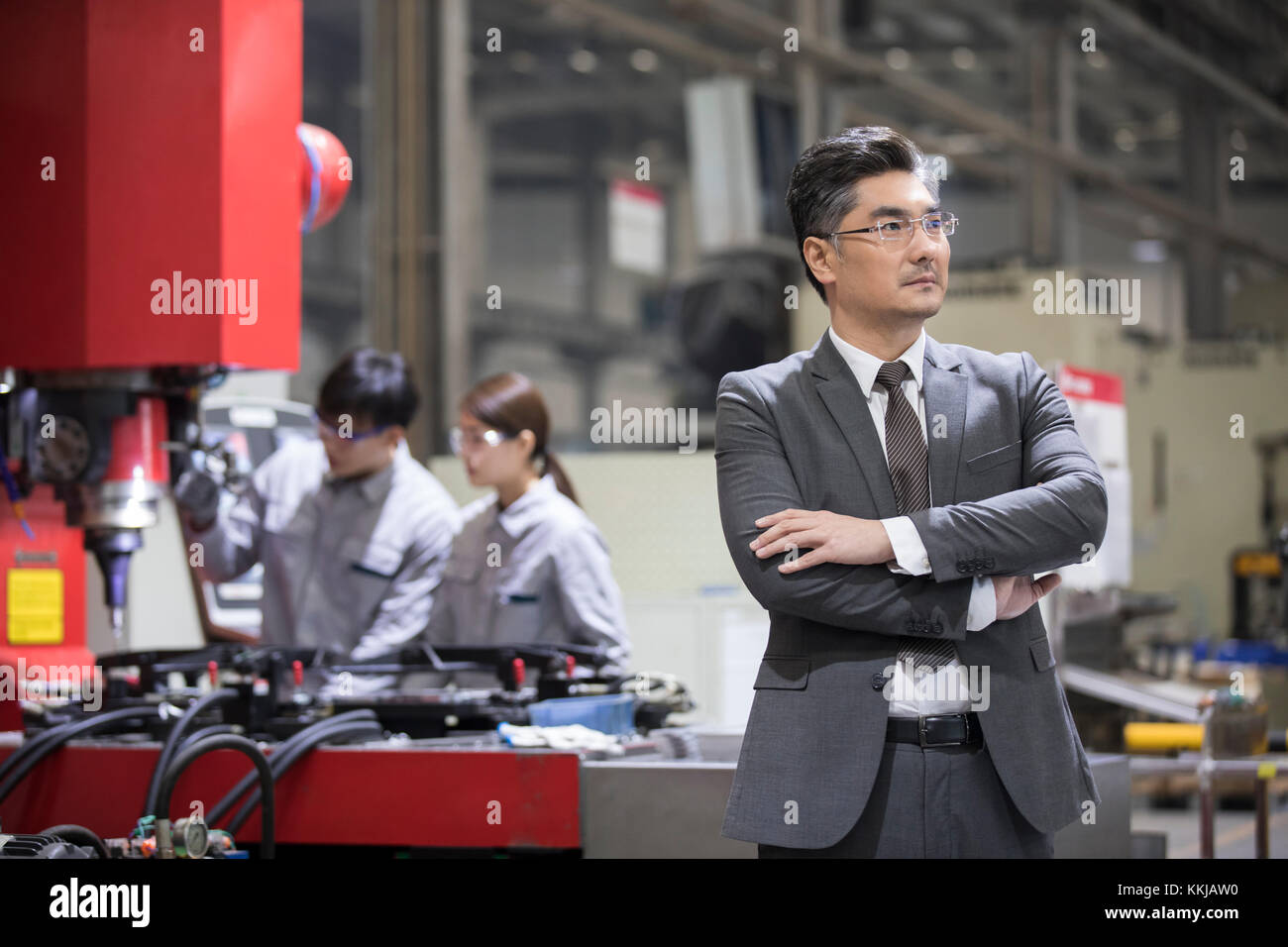 Confident Chinese businessman standing in the factory Stock Photo - Alamy