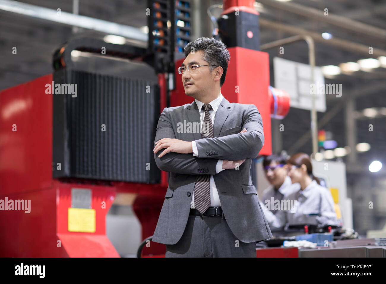 Confident Chinese businessman standing in the factory Stock Photo - Alamy