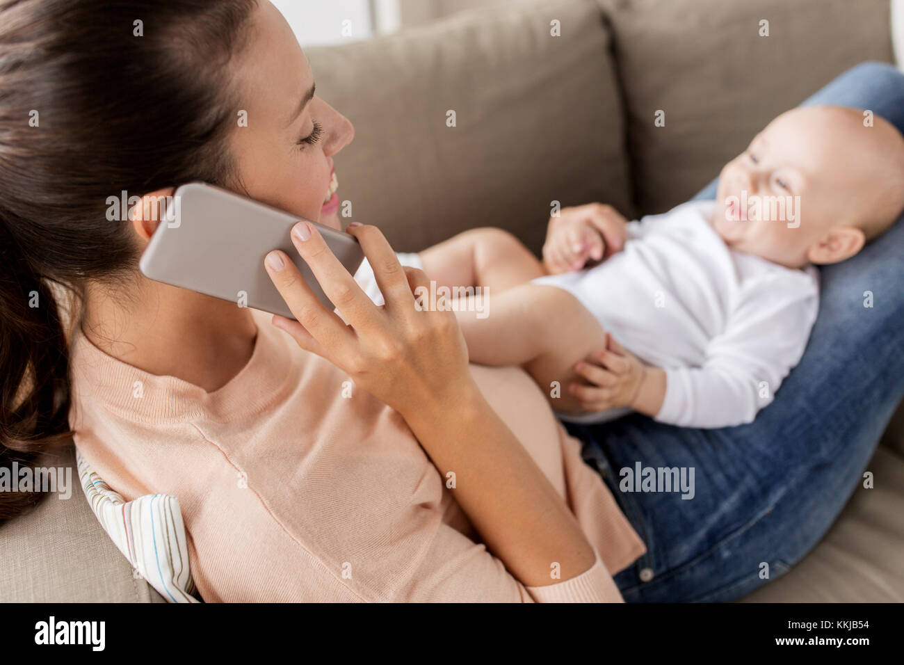 mother with baby calling on smartphone at home Stock Photo - Alamy