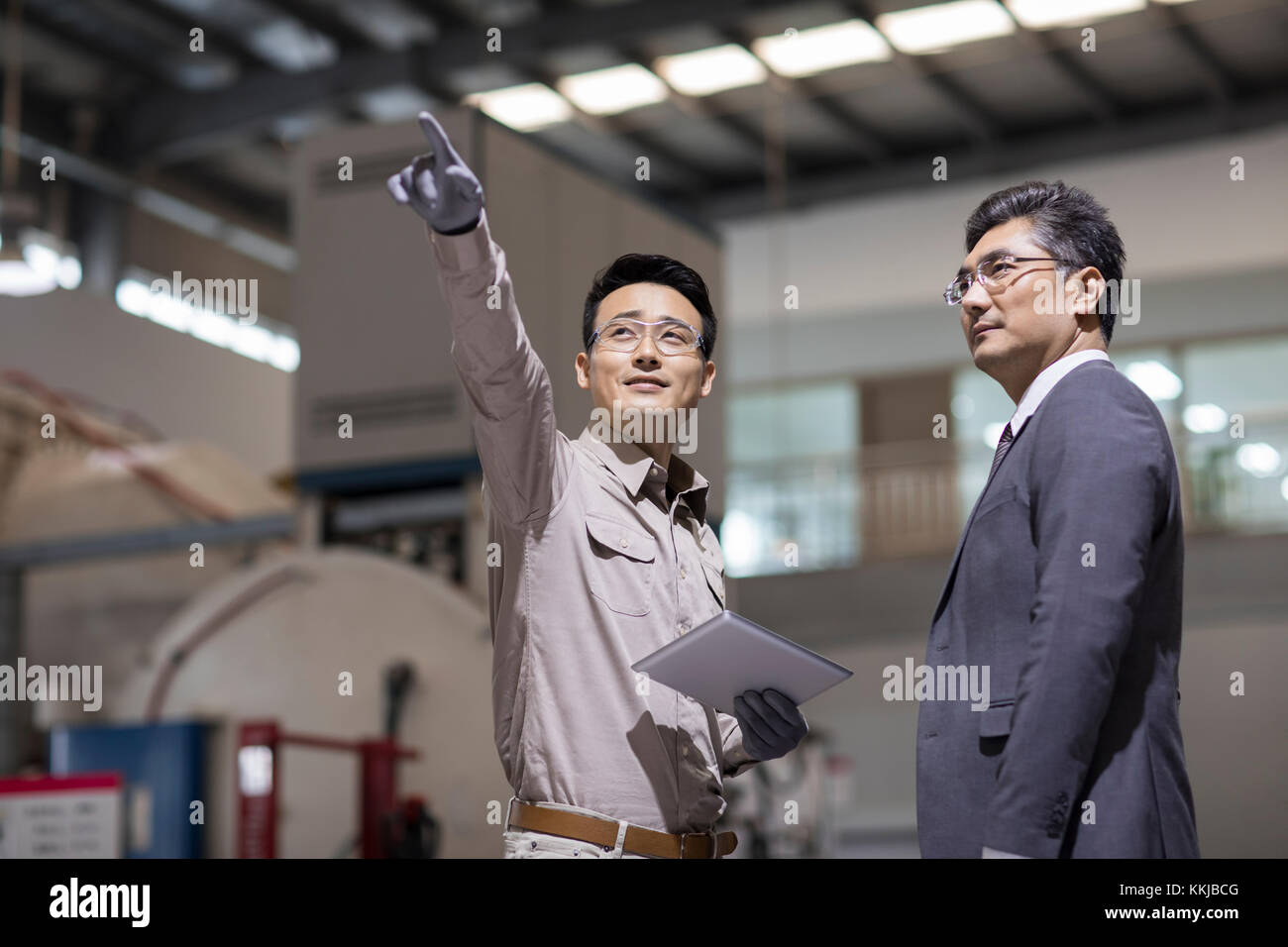 Chinese businessman and engineer talking in the factory Stock Photo - Alamy
