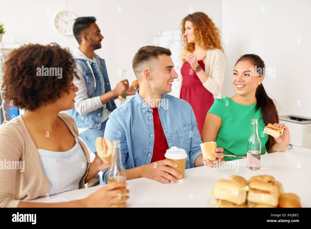 happy friends or team eating at office Stock Photo - Alamy