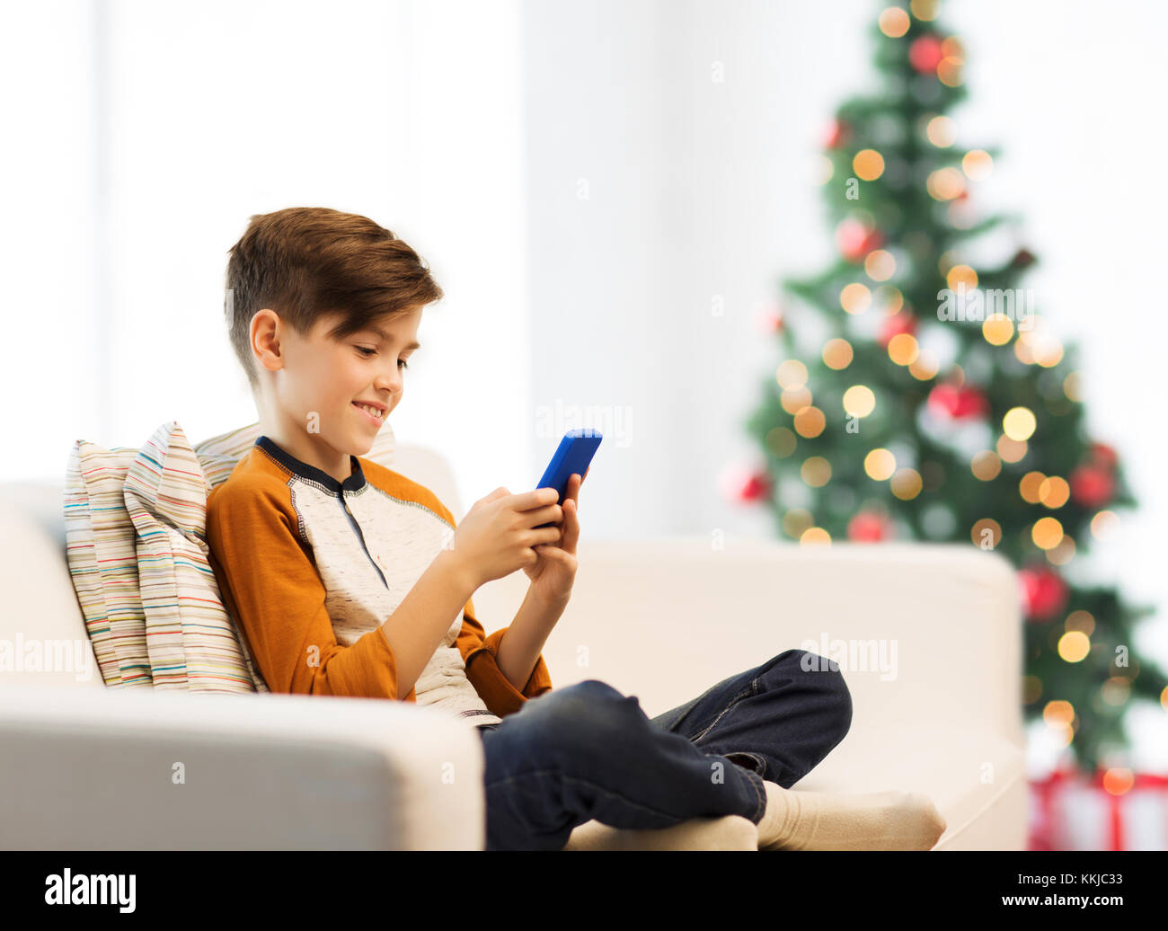boy playing on smartphone at home at christmas Stock Photo - Alamy