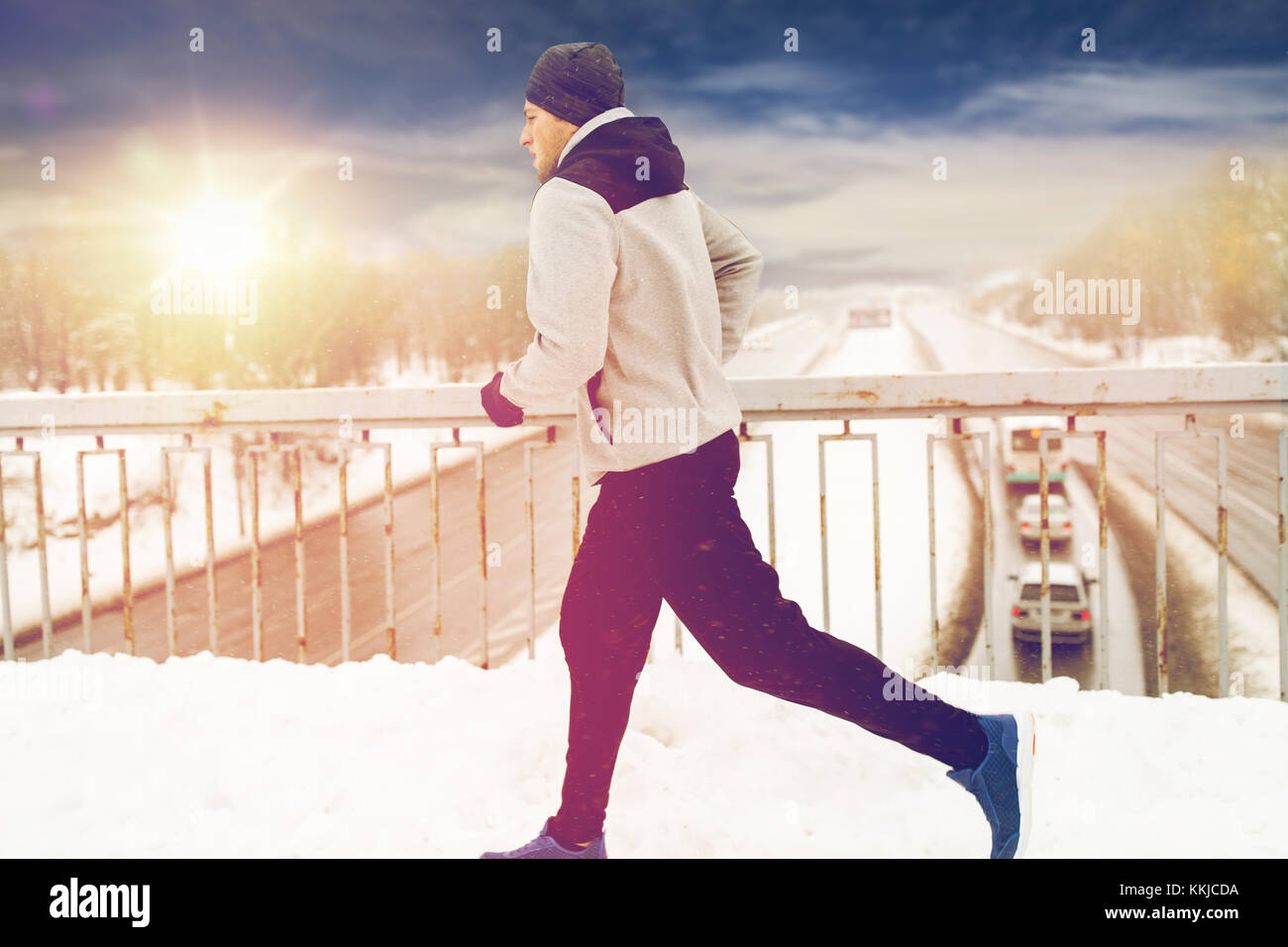 man running along snow covered winter bridge road Stock Photo - Alamy