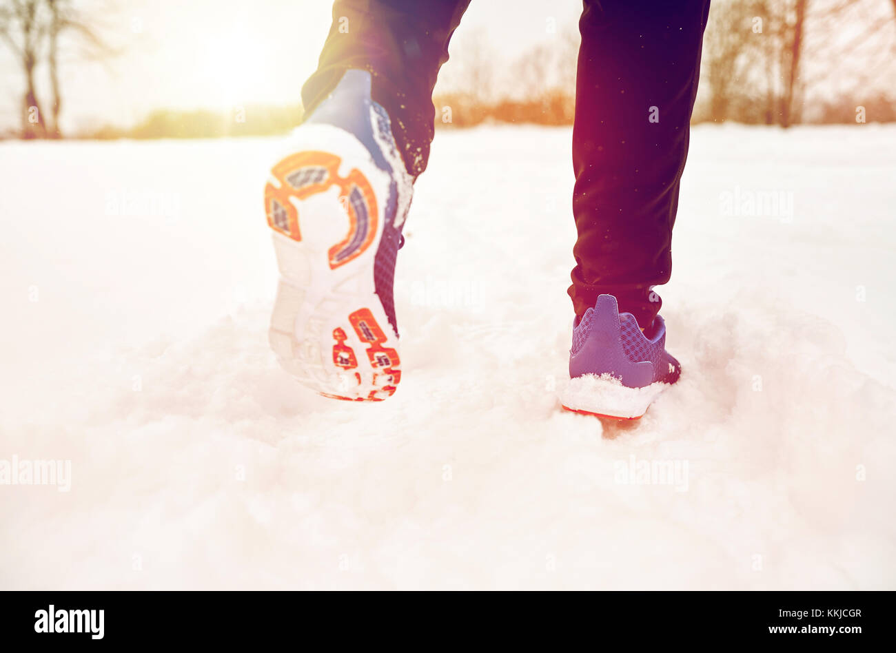 close up of feet running along snowy winter road Stock Photo - Alamy