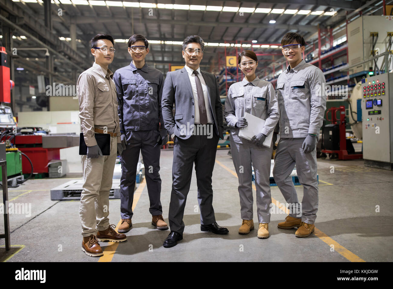 Confident Chinese businessman and engineering team in the factory Stock ...