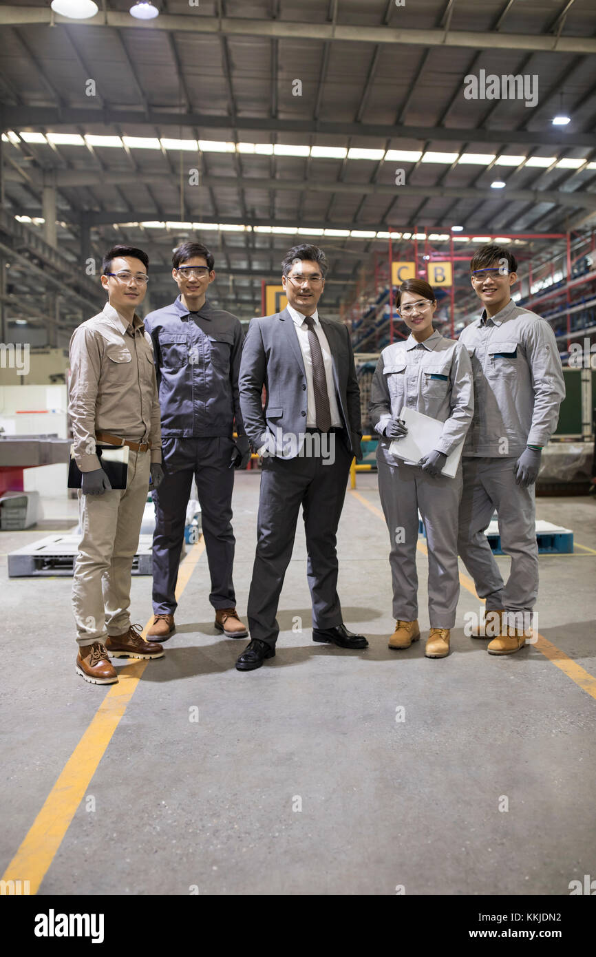 Confident Chinese businessman and engineering team in the factory Stock ...