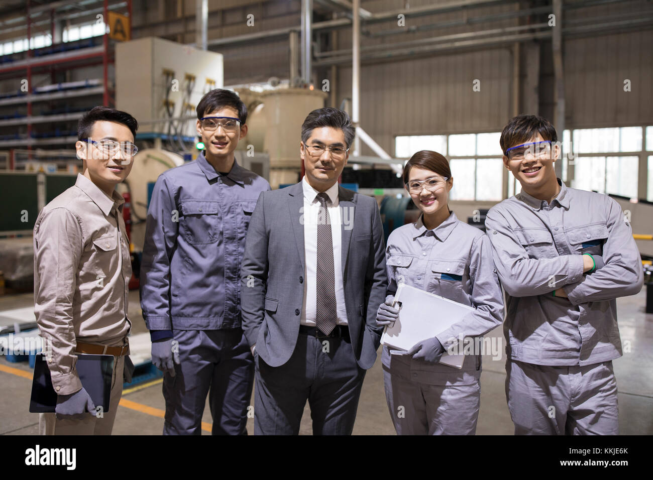Confident Chinese businessman and engineering team in the factory Stock ...