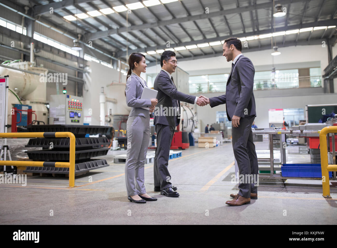 Business people shaking hands in the factory Stock Photo - Alamy