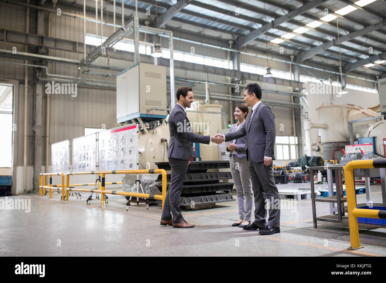 Business people shaking hands in the factory Stock Photo - Alamy