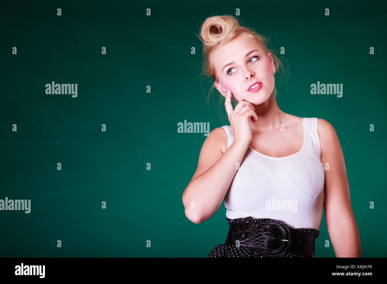 Young blonde woman in retro vintage hairstyle wearing white top making ...