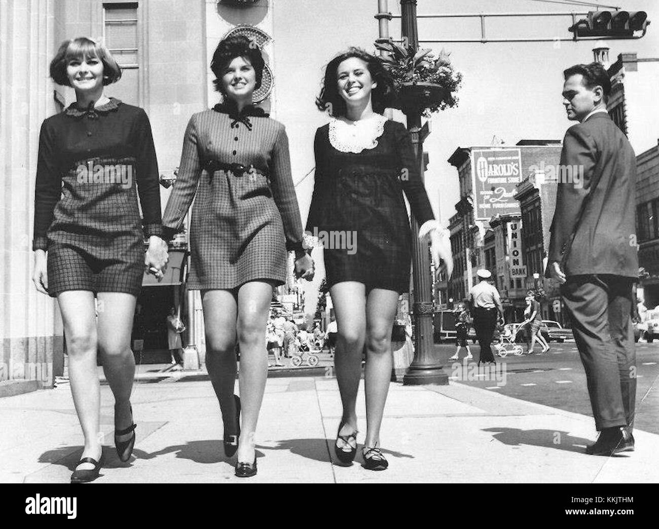 This 1965 photograph shows models walking on the sidewalk outside Hess ...