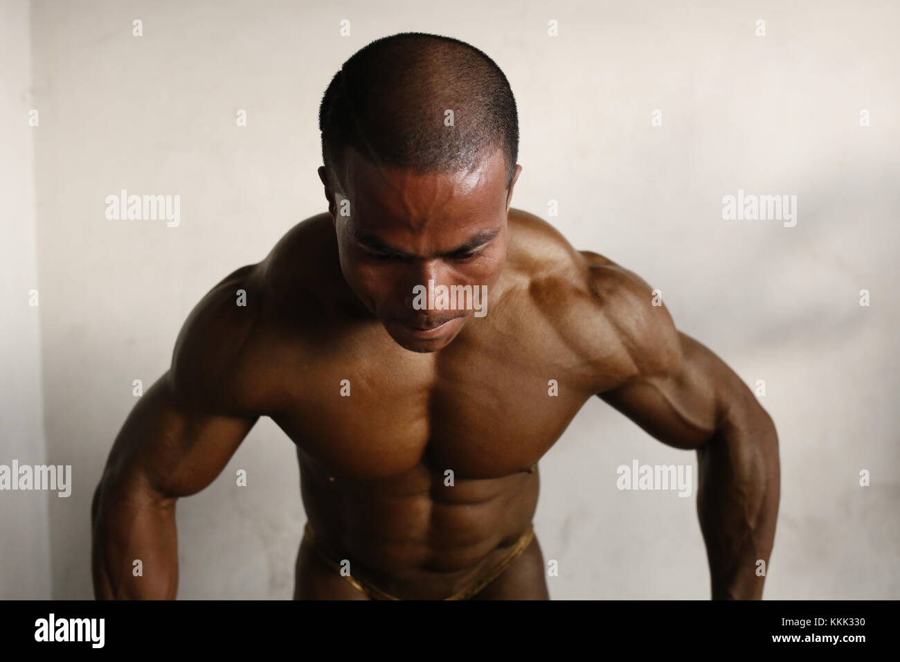 Dhaka, Bangladesh. 30th Nov, 2017. A Bodybuilder warms up backstage ...