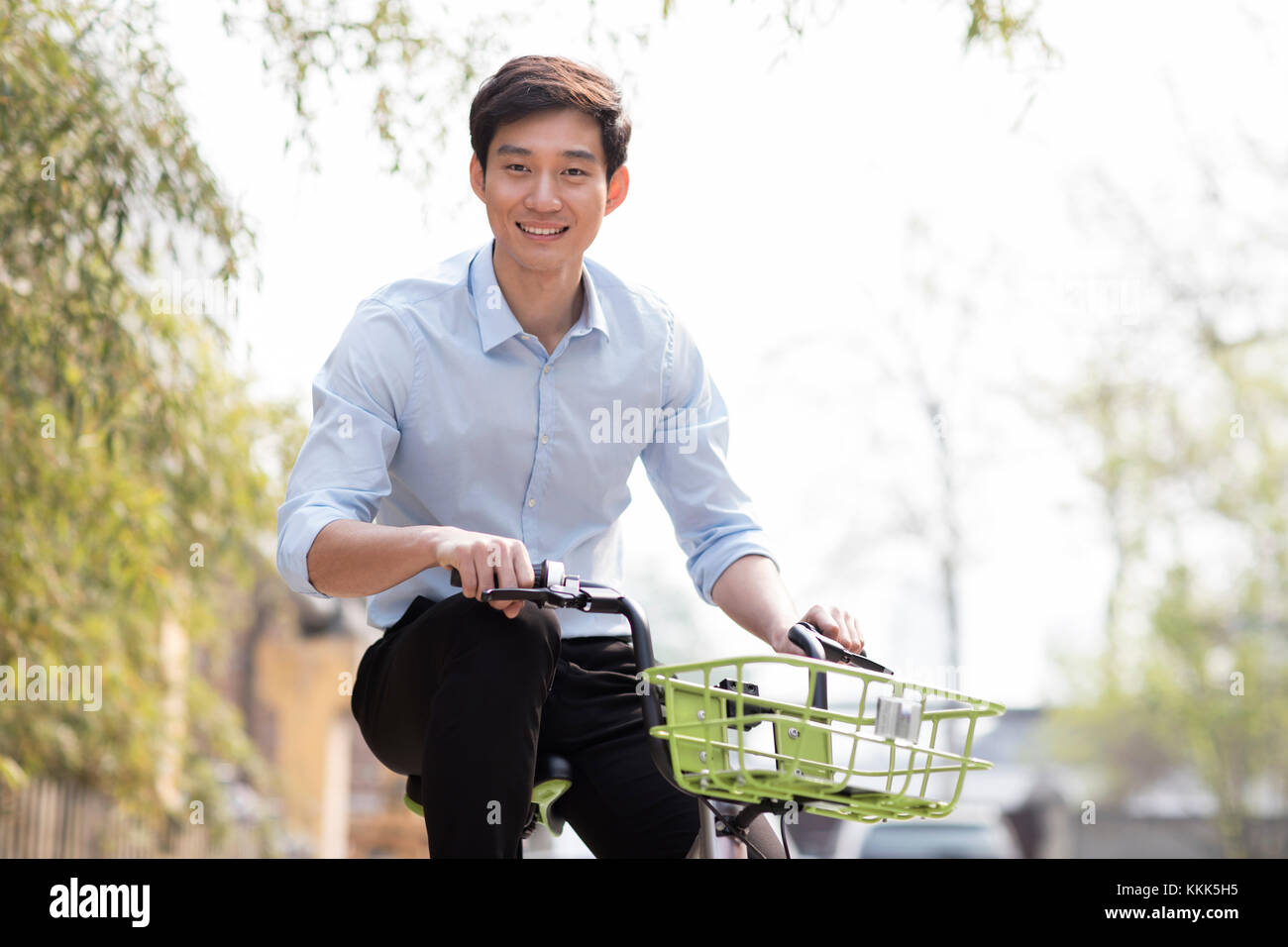 Young Chinese man riding a share bike Stock Photo - Alamy