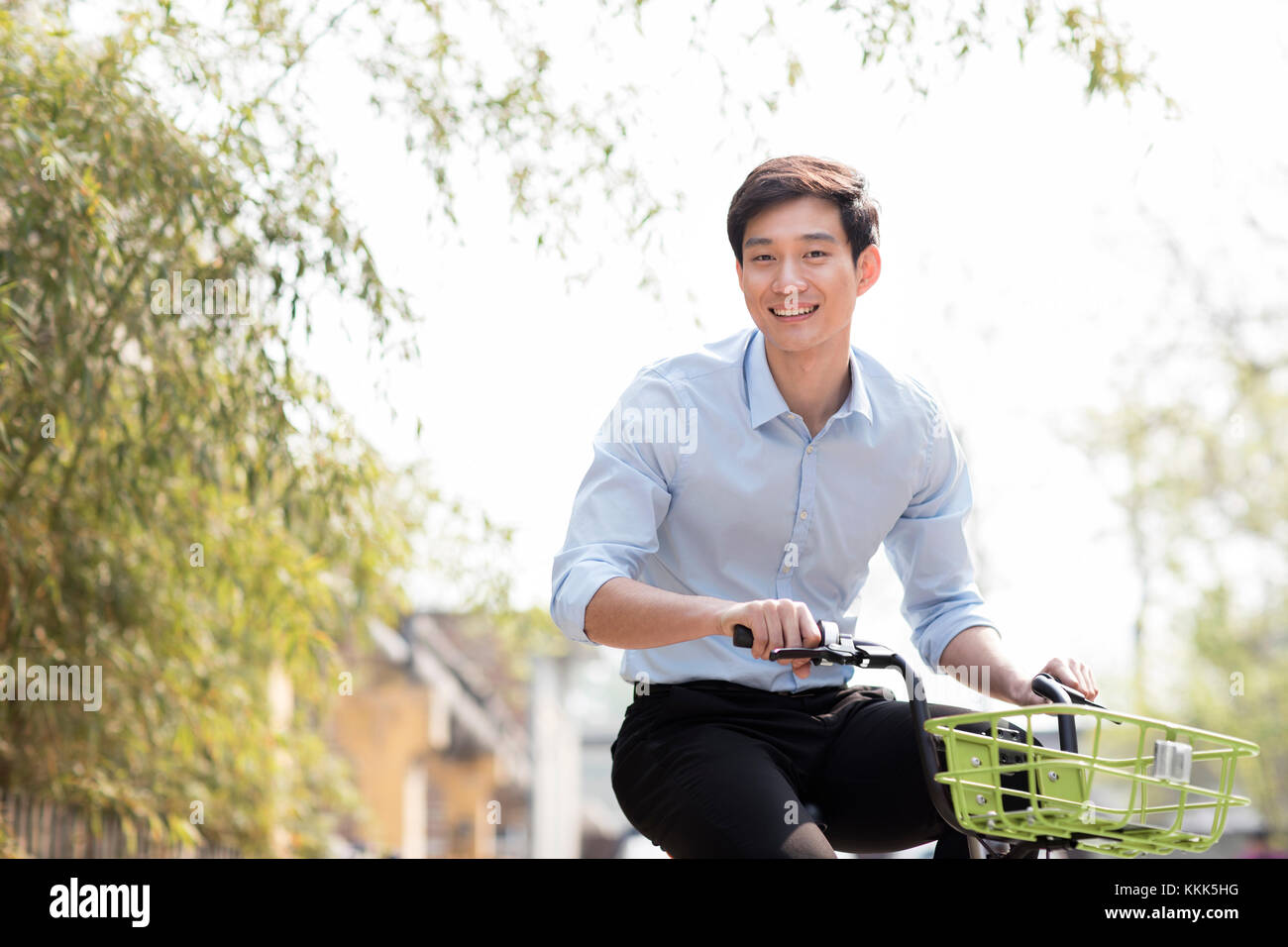 Young Chinese man riding a share bike Stock Photo - Alamy