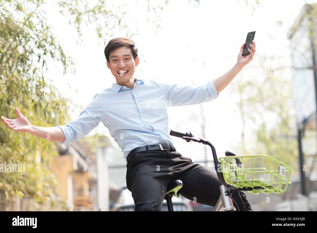 Young Chinese man riding a share bike Stock Photo - Alamy