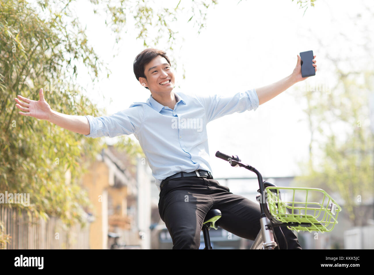 Young Chinese man riding a share bike Stock Photo - Alamy