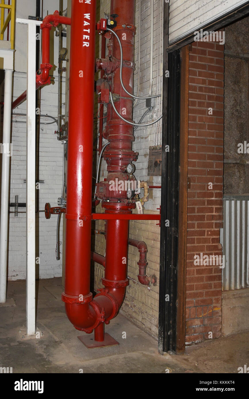Red-painted fire-suppression pipes are shown near an opened vertical ...