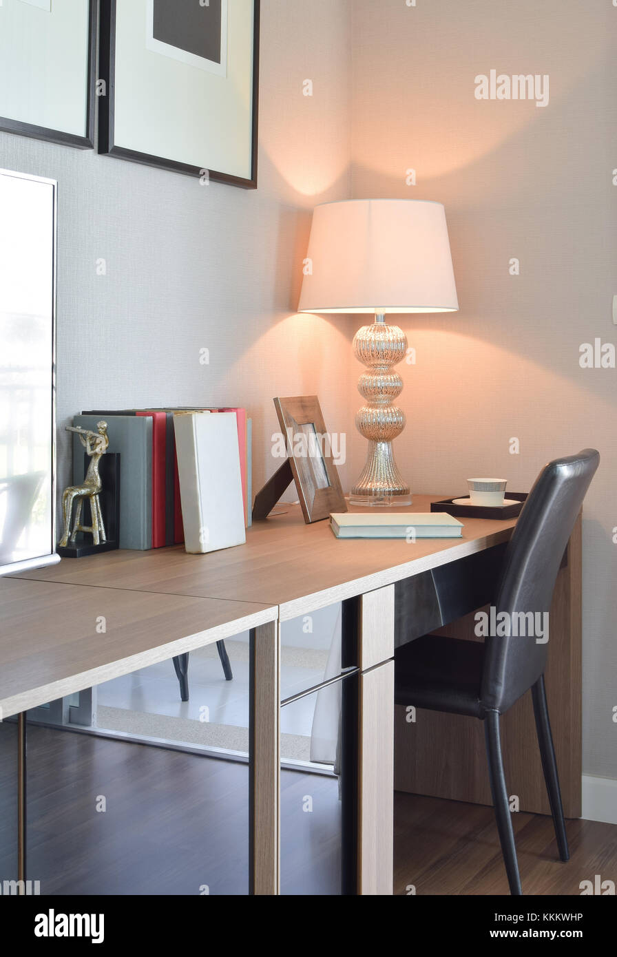 wooden table with lamp and books in modern working room interior Stock ...