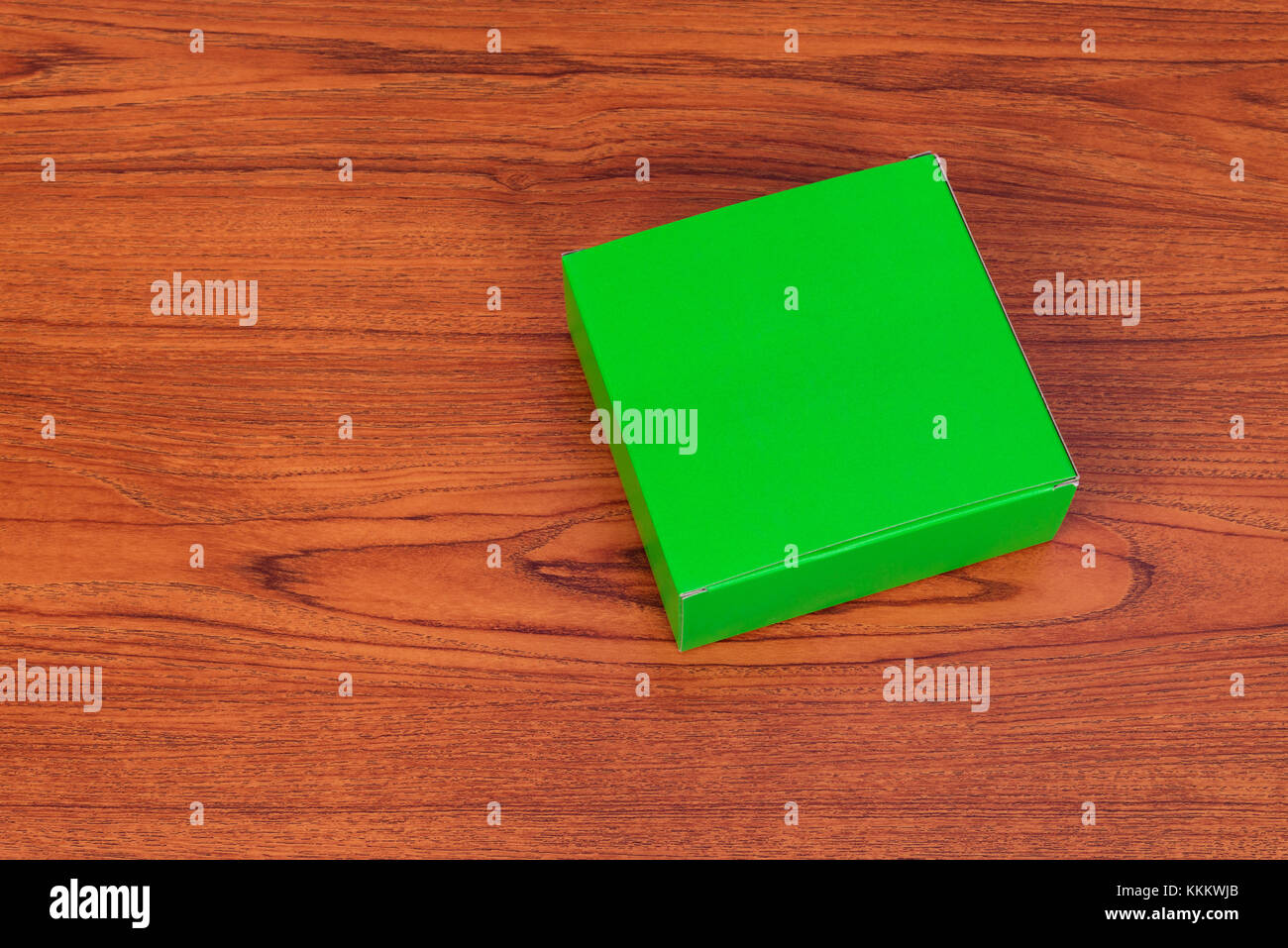 Empty closed green cardboard box for mock up on bright wooden table ...