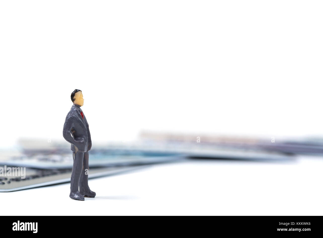 Figure miniature businessman or small people standing with stack of ...